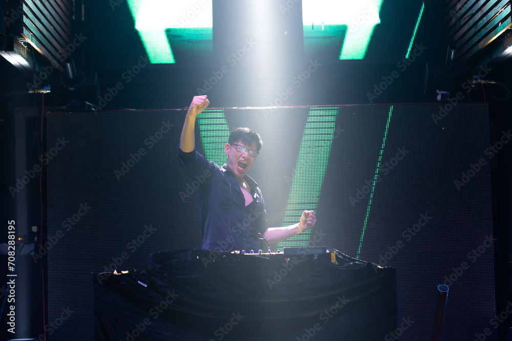 DJ with Turntables at nightclub. Group of diverse young people dancing ...