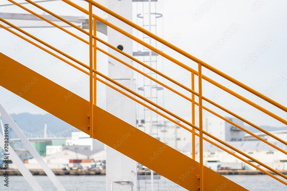 Side view at the yellow metal railing banister or handrail of the metal ...