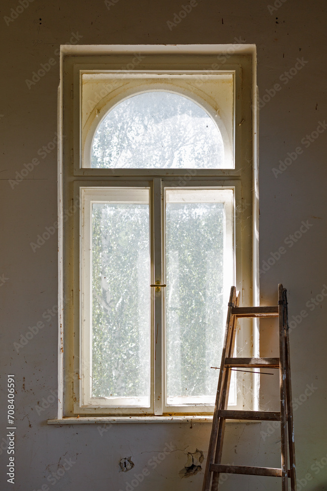 A wooden staircase by the window in an old house. Restoration and ...