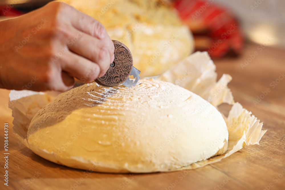 Bread scoring. Close up photo with a male hand scoring the sourdough ...