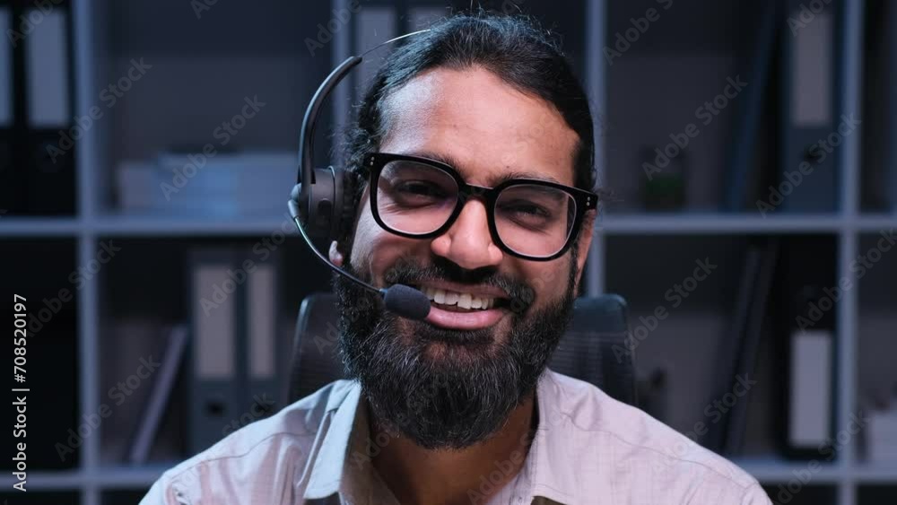 Smiling Indian call center employee is captured in a portrait, looking ...