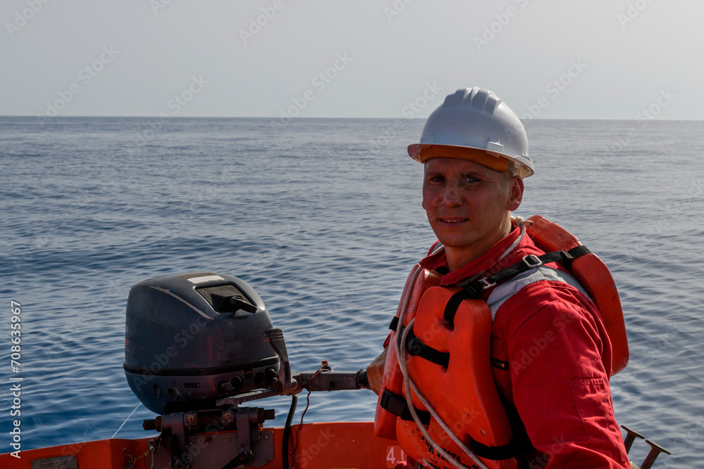 Orange rescue boat with crew at sea. Man overboard drill. Lifeboat ...