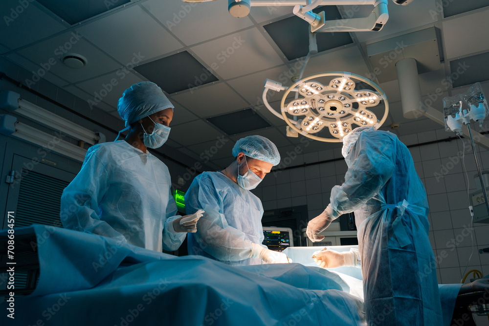 Low-angle view of diverse cooperating team of doctors, surgeons and ...