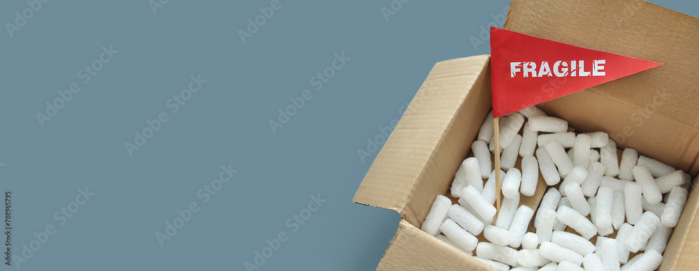 Opened cardboard packaging box with white polystyrene packing chips ...