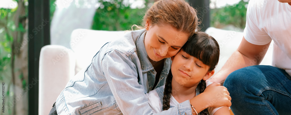 Parents comforting their daughter with loving hug, helping her feel ...
