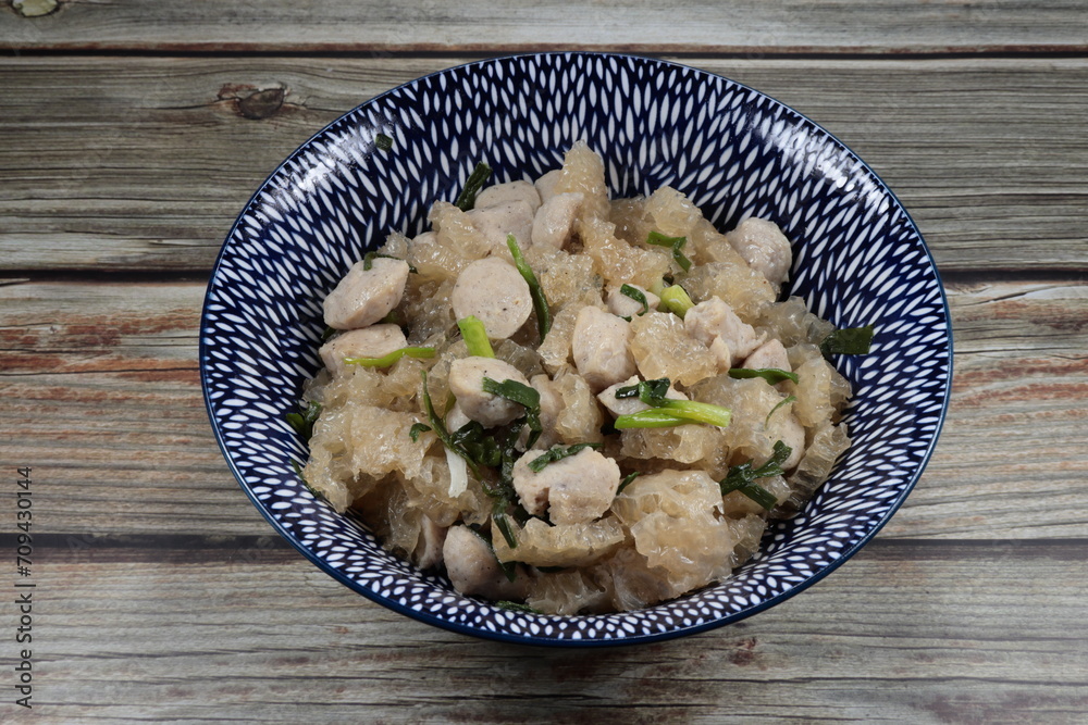 Traditional fried and stirred fresh pork skin with pork ball serving in ...