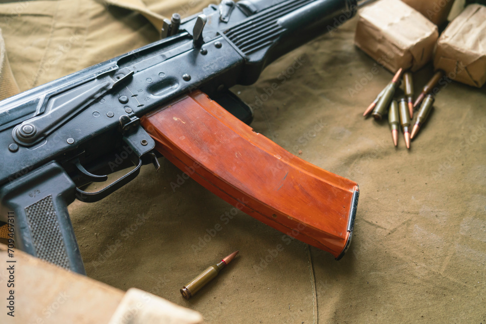 Kalashnikov assault rifle and ammunition for it on the Soviet raincoat ...