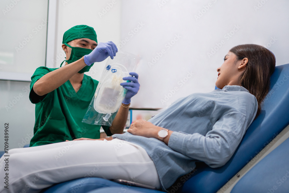 doctor shows new empty blood bag to donor before blood transfusion in ...
