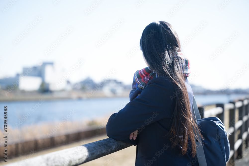 Faceless high school girl standing by the river thinking about her ...