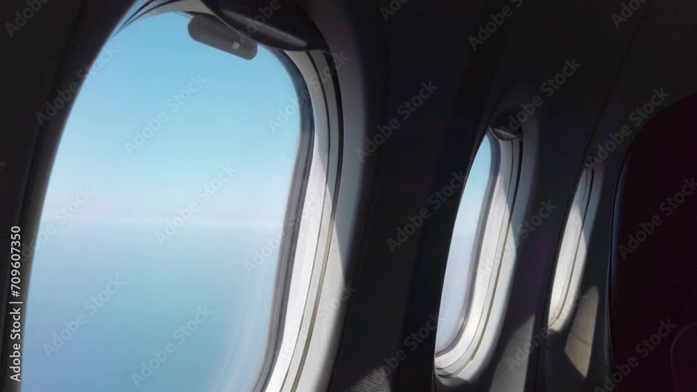 Daytime view from inside the airplane, looking out of the windows with ...