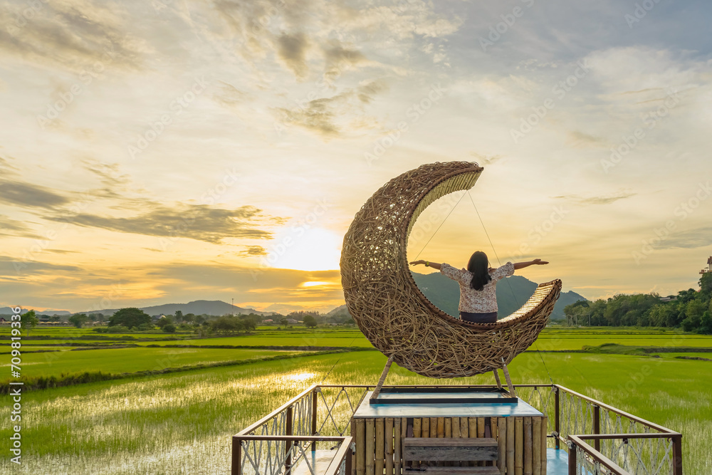 Woman sit on crescent moon chair made of rattan for relaxation on ...