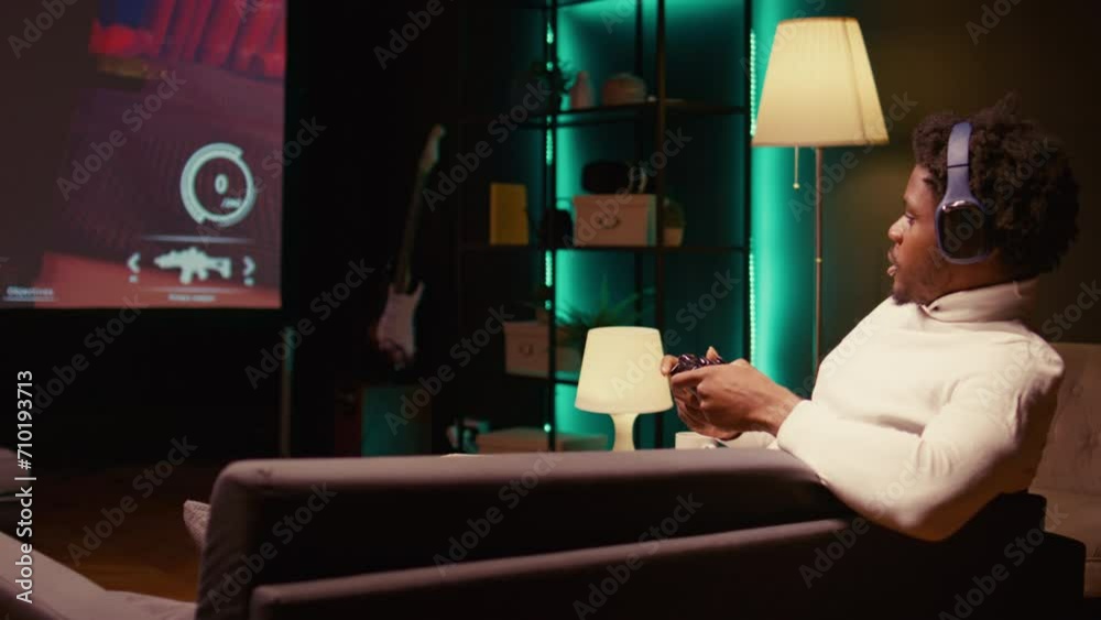 Man playing multiplayer videogame on gigantic smart TV, wearing ...