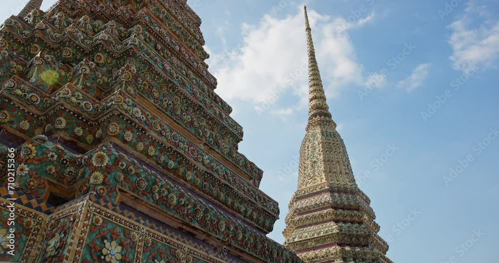 Low angle tilt reveal Wat Pho temple spire tower decorated with ...