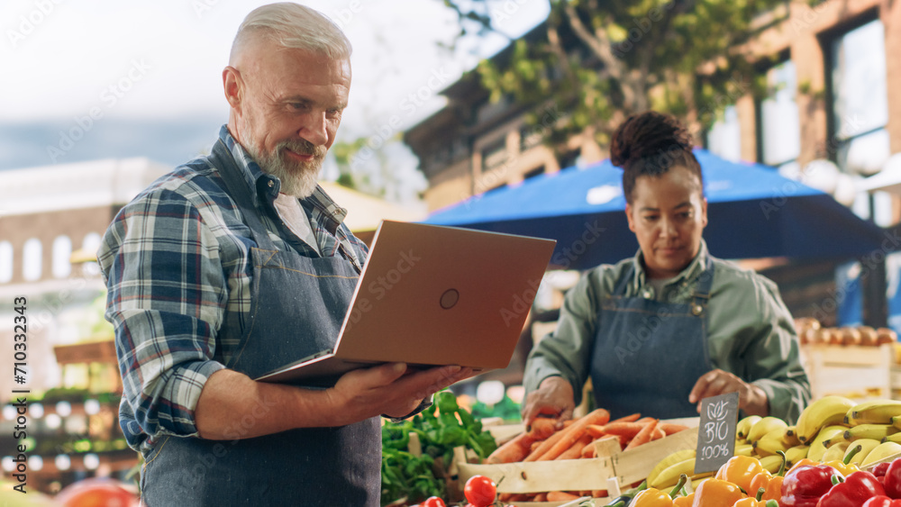 Market Manager Using Laptop Computer while Standing Next to Street ...