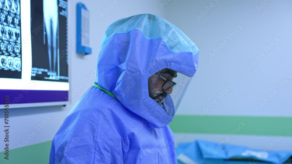 Male surgeon wearing protective medical suit and helmet. Side view ...
