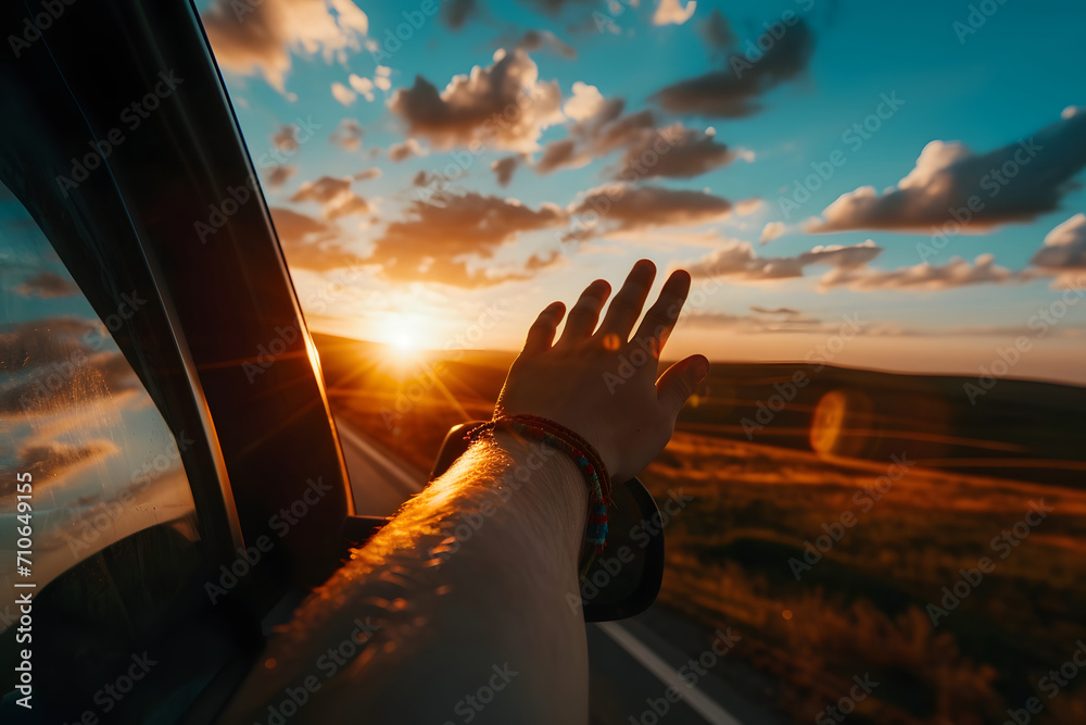 Road trip journey, hand held out from an opened window of car with the ...