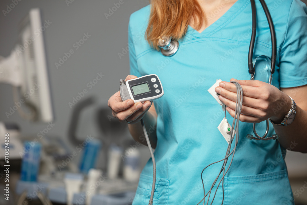 Doctor showing ECG holter monitor to patient in pediatric clinic ...