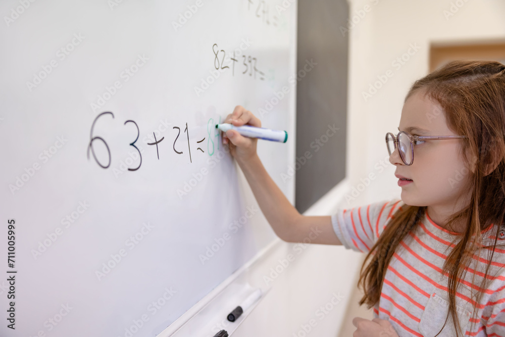 Little girl counting math equation on whiteboard in school. Stock Photo ...