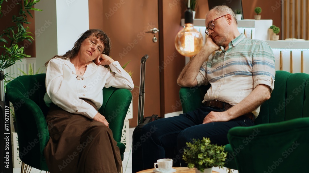 Tired old people falling asleep on sofa at hotel, feeling exhausted ...