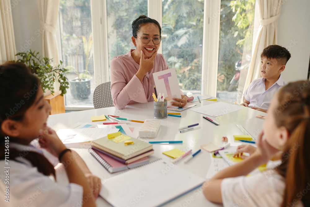 Teacher explaining kids how to mouth muscles works when pronouncing ...