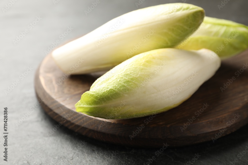 Fresh raw Belgian endives (chicory) on black table, closeup Stock Photo ...