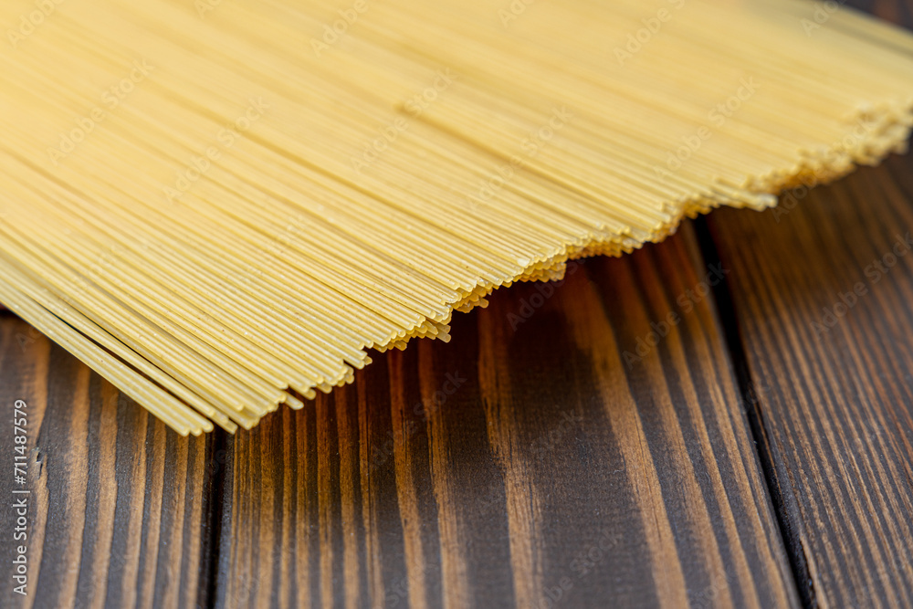 Yellow long spaghetti on a rustic background. Yellow italian pasta ...