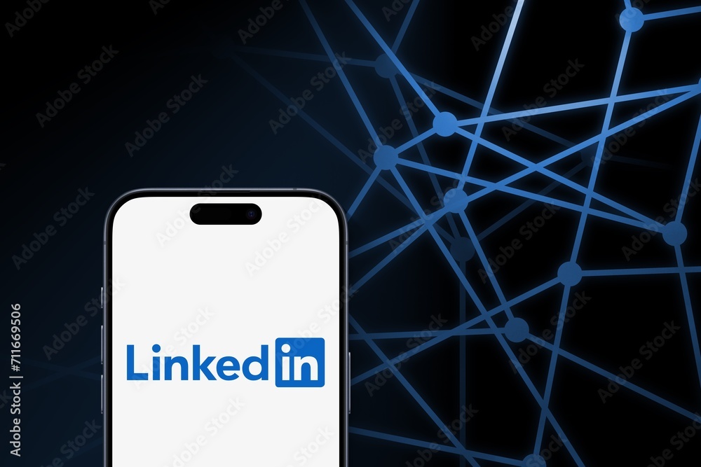 Linkedin logo is displayed on a modern smartphone, blue connected dots ...