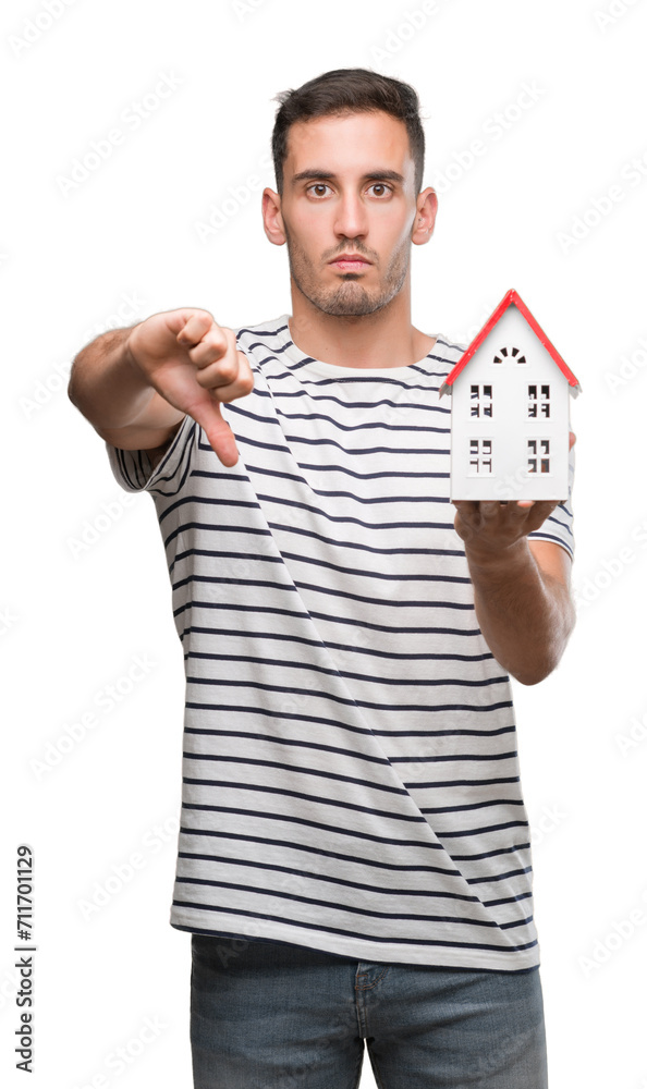 Handsome real estate agent holding a house with angry face, negative ...