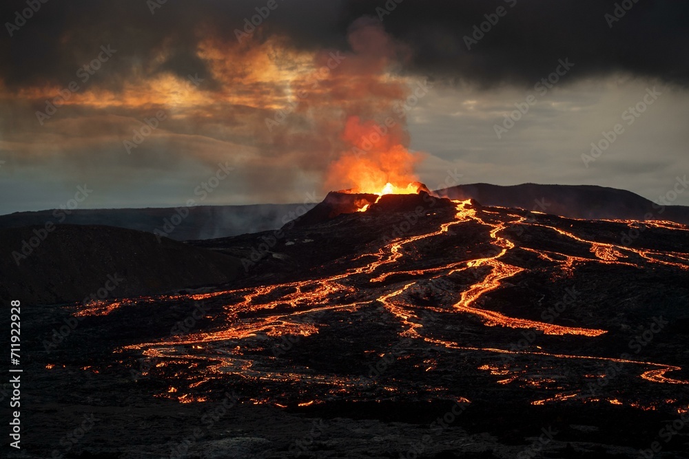 Lava spurting out of crater and reddish illuminated smoke cloud, lava ...