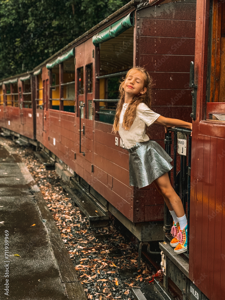 Beautiful toddler girl standing on the train portrait. Vintage railway ...