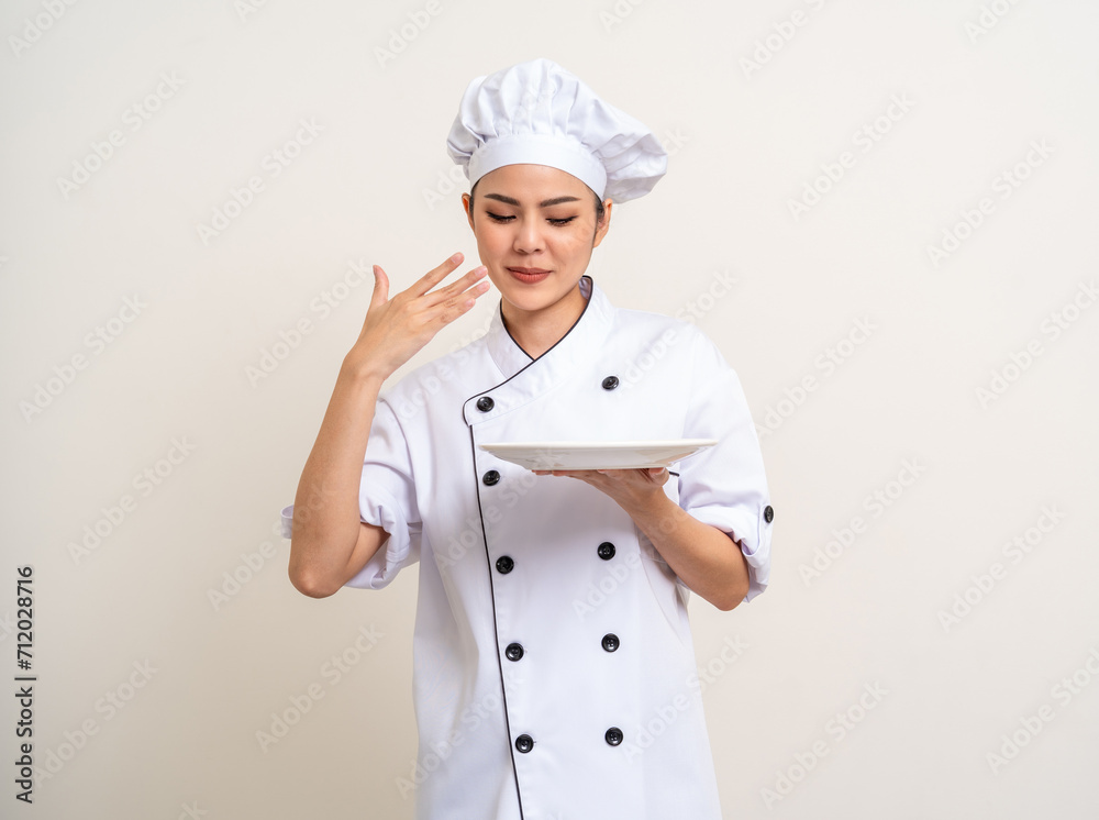 Bad smell and not tasty food. Young asian woman chef in uniform holding ...