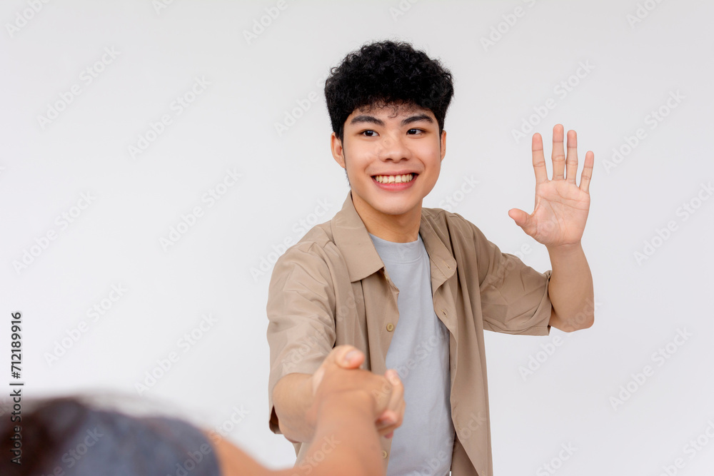 Bright portrait of a young friendly Asian man saying hi and giving a ...