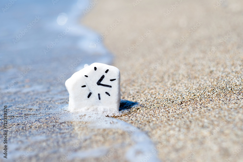 Foto de DIY clock made on the beach from a stone in the sand on the ...