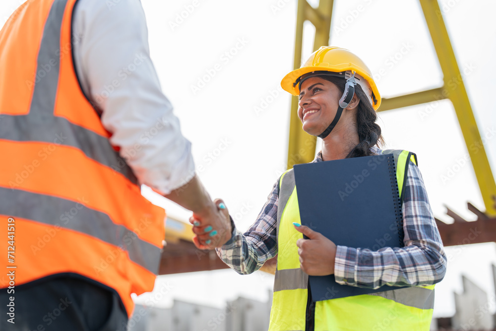 Asian female civil engineers wearing vest and helmet safety handshake ...