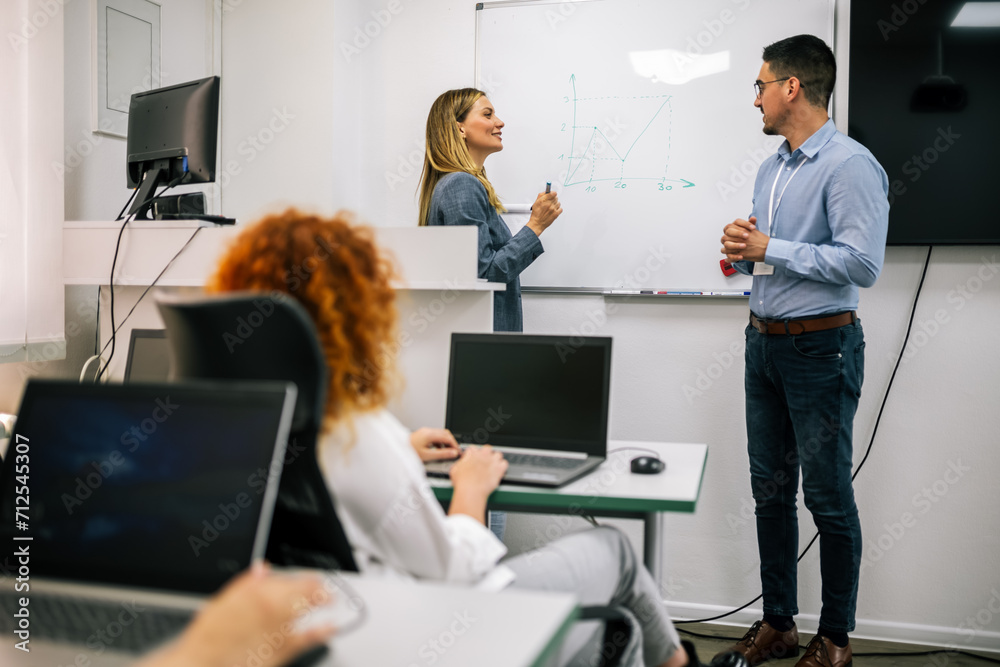 Young teachers teaching young students a programming class in the ...