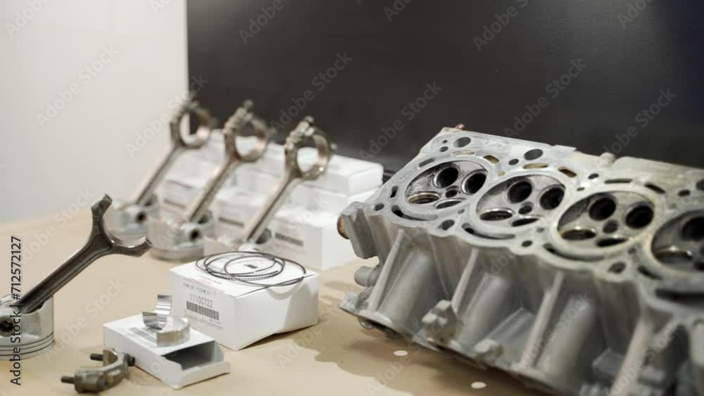 Disassembled engine parts displayed for overhaul. Cylinder head ...