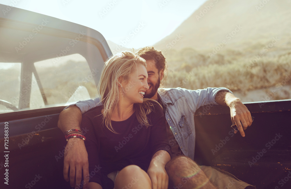 Group of friends laughing and drinking beer at the back of a car on a ...