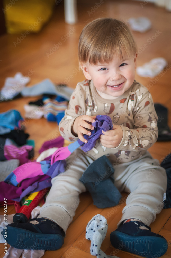 Happy cute and laughing baby boy is completely engrossed in examining a ...