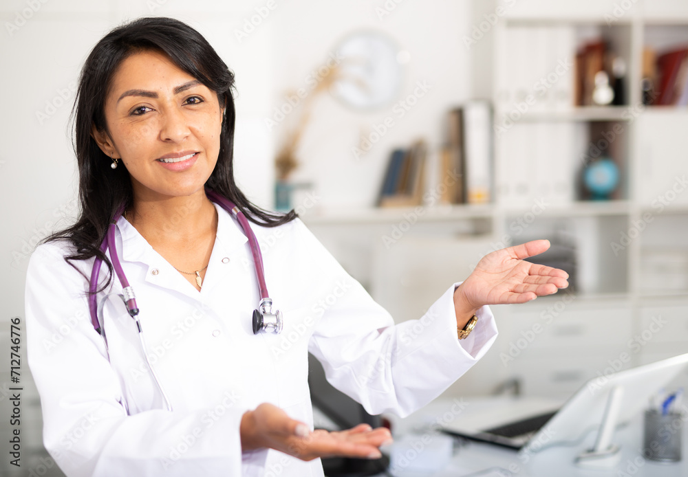 Polite female doctor making welcome gesture, politely inviting patient ...