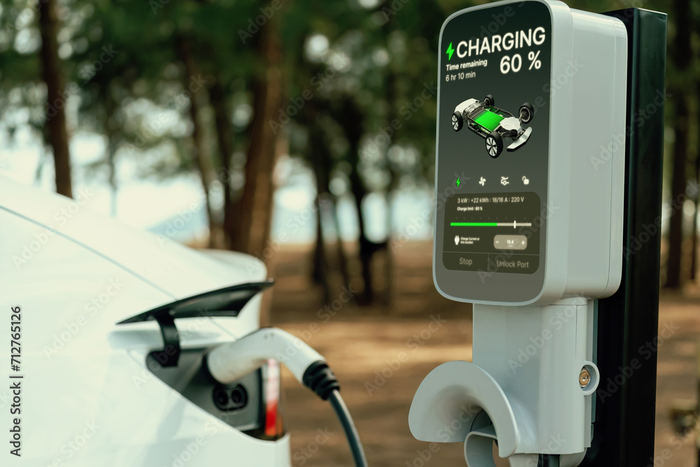 Electric car recharging battery at outdoor EV charging station for road ...