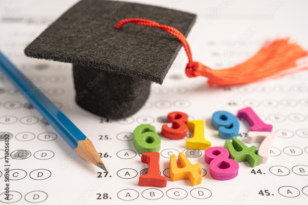 Graduation gap hat and pencil on answer sheet paper, Education study ...