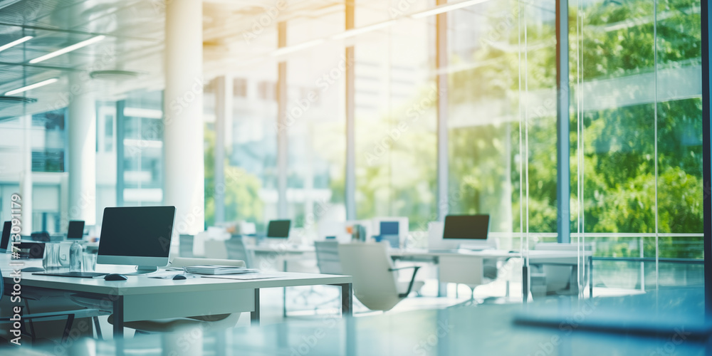 Blurred empty modern open space office with large windows and green ...