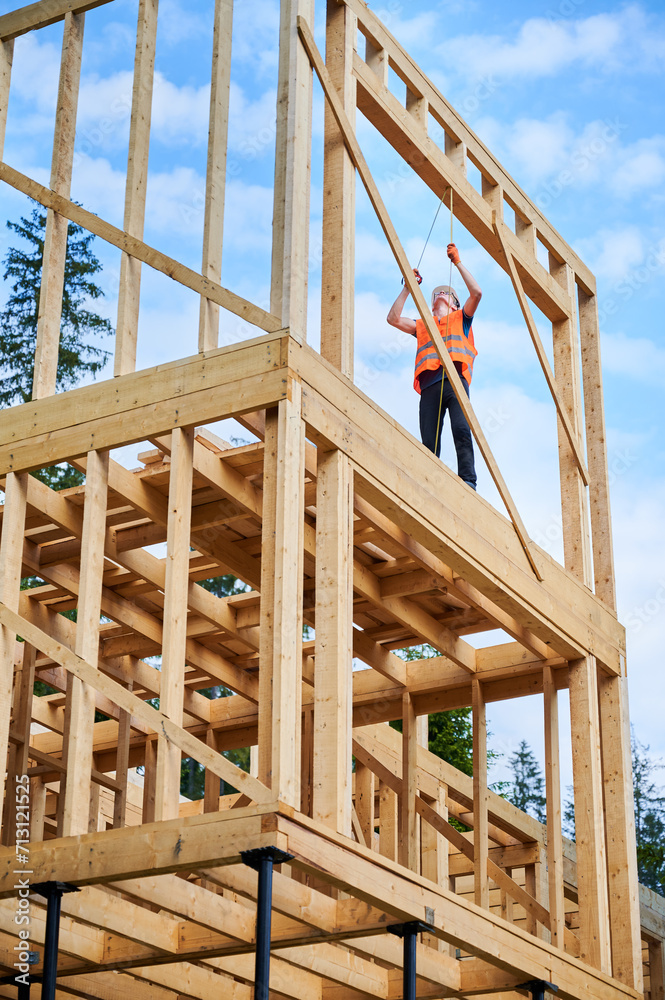 Carpenter is erecting wooden frame two-story house. Man taking ...