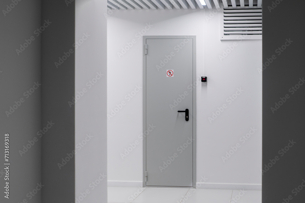 This image shows a closed white door in a contemporary building with a ...