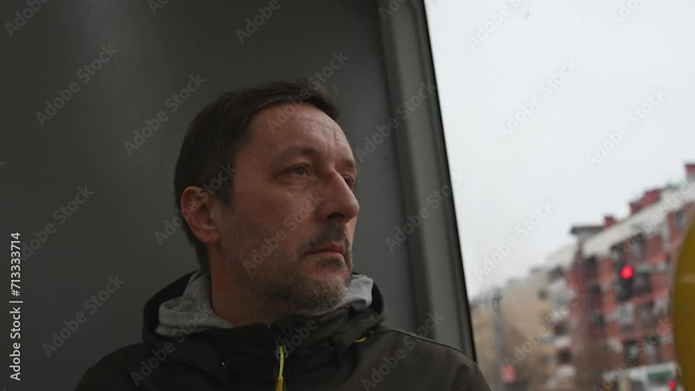 Unhappy melancholic male looking out the window of public ...