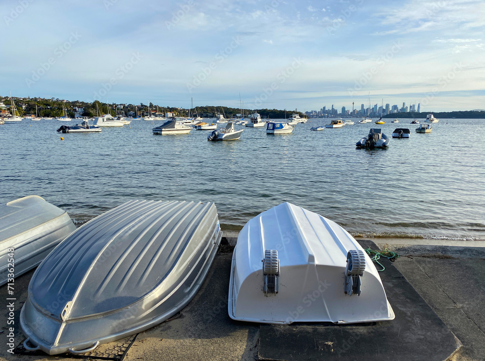 Canoes on the beach along the shore of the ocean. Sailing boats at the ...