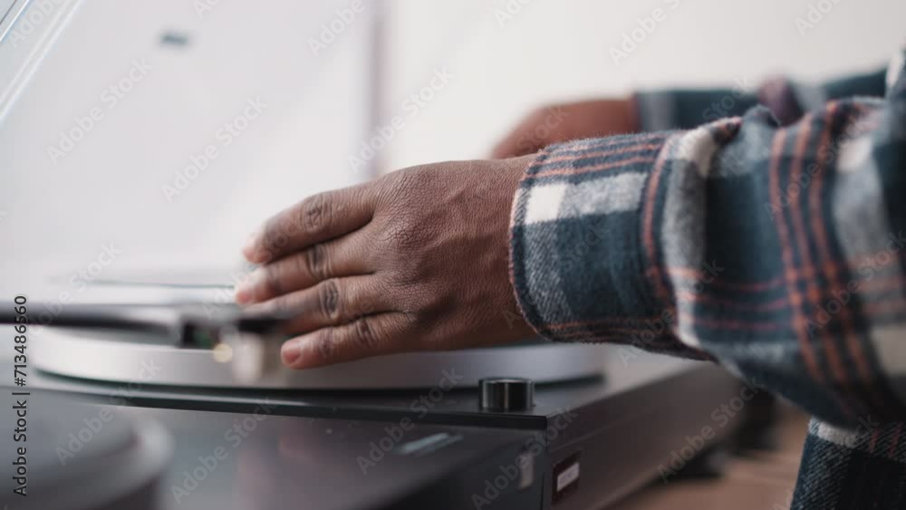 Man puts vinyl record on turntable. African American melomaniac spends ...