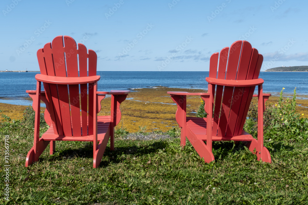 Red chairs at Rocky Harbor in Gros Morne National Park, a Canadian ...