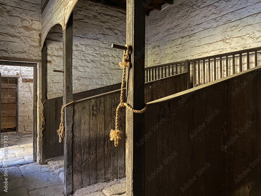 Centuries-old stable with empty wooden stalls. Antique barn. Ancestral ...