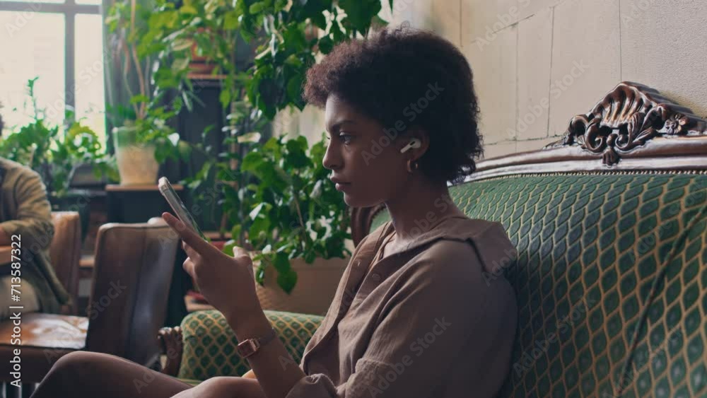 Medium side shot of busy young African American woman with wireless ...